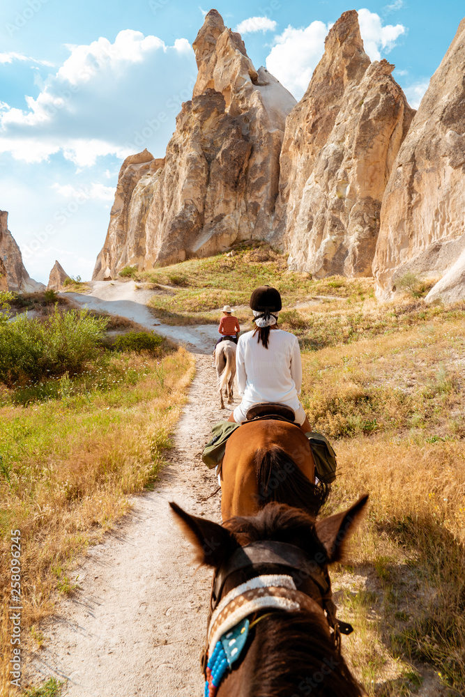 happy young couple man and woman Horseback riding through the national ...