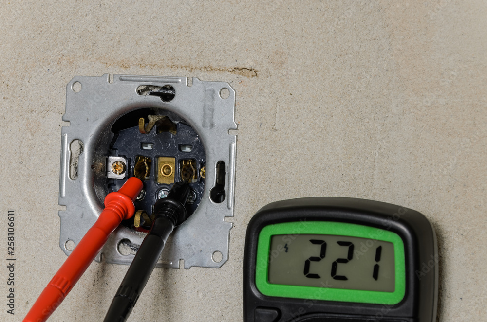 Measurement of network voltage in the outlet with a multimeter Stock ...