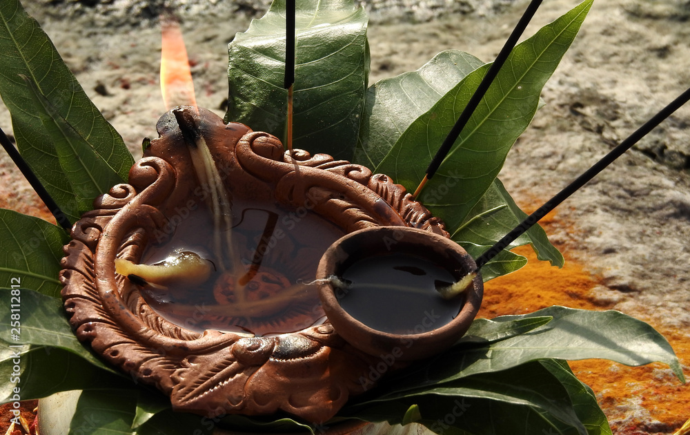 Hindu woman pray sun God, with lighted oil, eathen pot lamp, at dusk,in ...