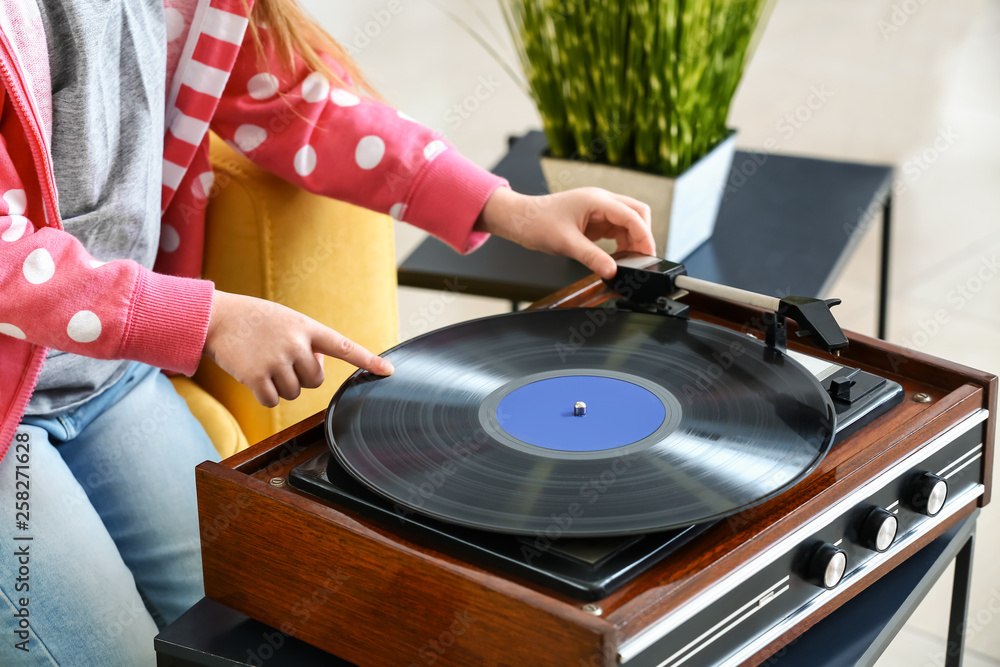 Cute little girl listening to music through record player at home Stock ...