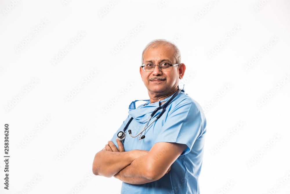 Senior Indian male surgeon in blue dress, standing with stethoscope ...