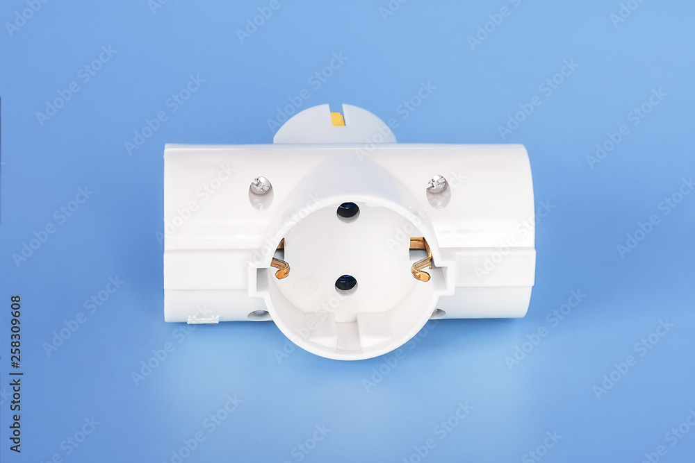 White splitter for 220 volt electricity grid on a blue background ...
