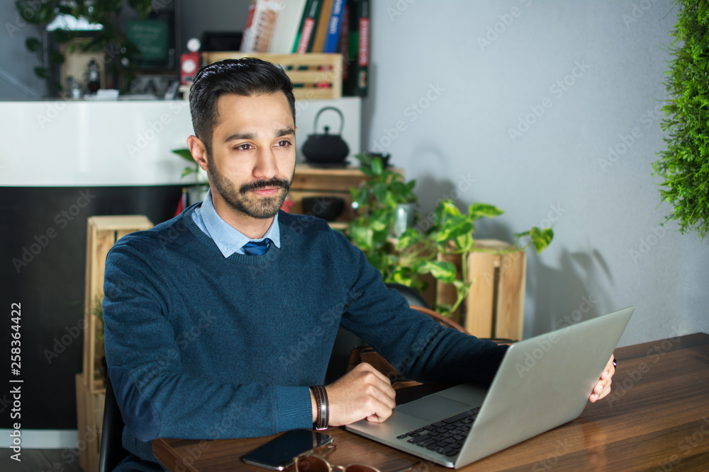 Pakistani young man working with laptop in office Stock Photo | Adobe Stock