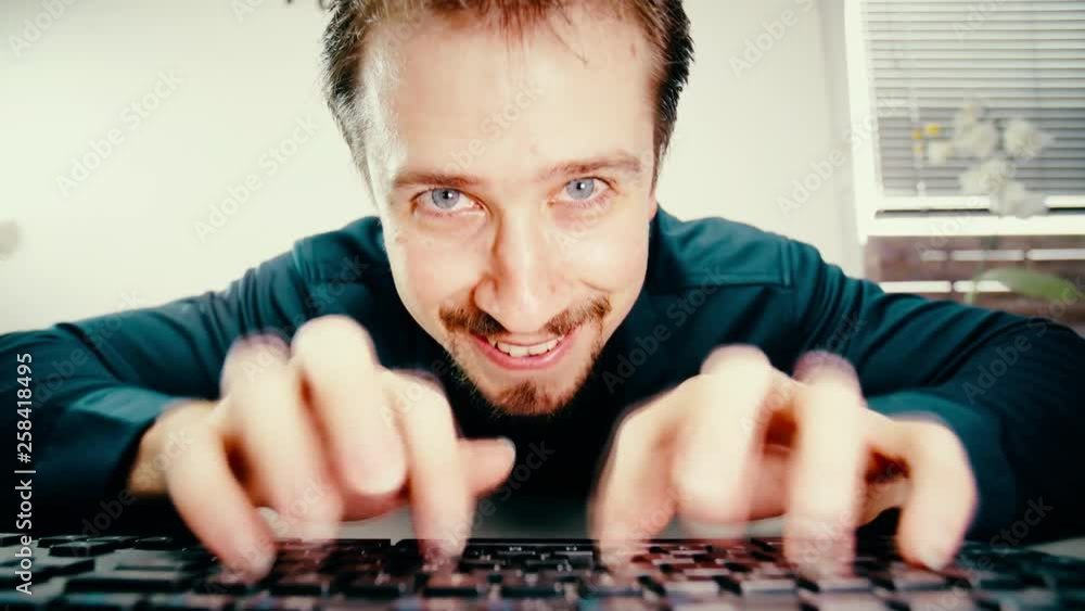 Man extreme fast typing and stare into camera 4K. Low angle view from ...