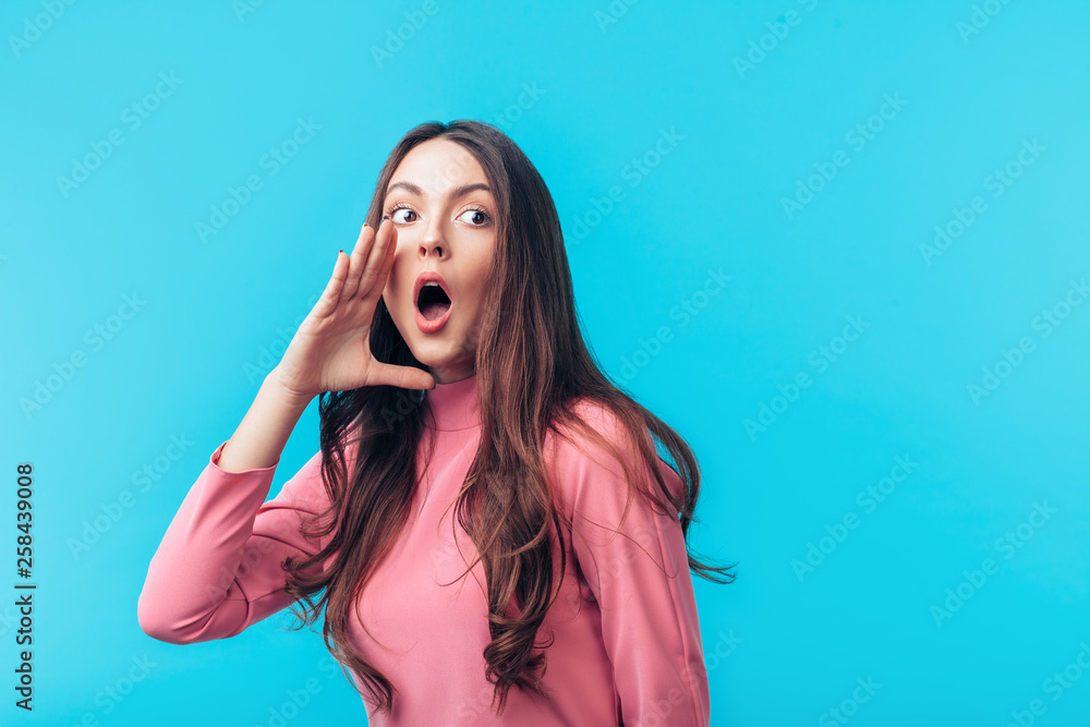 Crying emotional woman screaming holding hand near mouth on blue ...