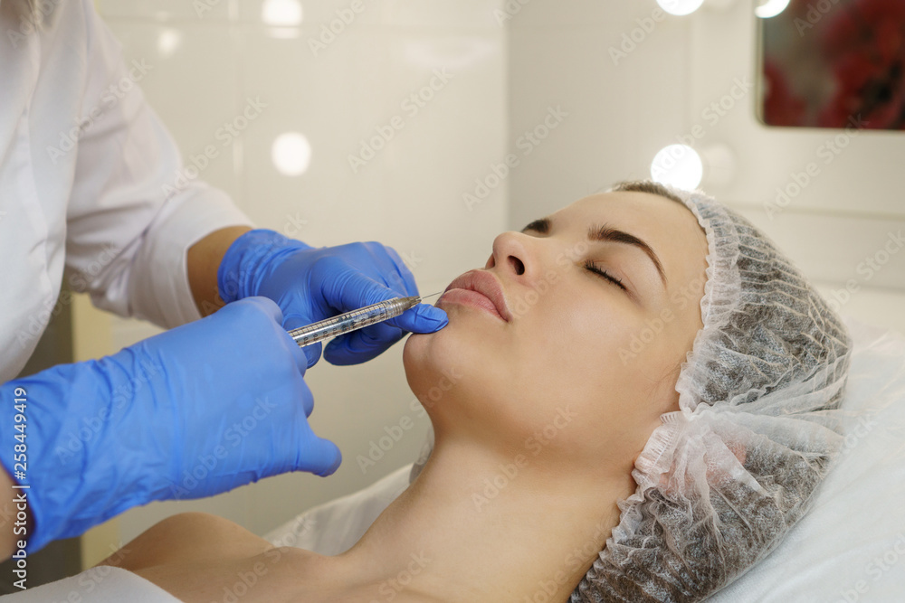 Aesthetic cosmetology. Facelift in spa salon. Beautician makes ...