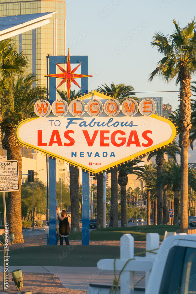 early morning sun illuminating las vegas sign and vegas skyline behind ...