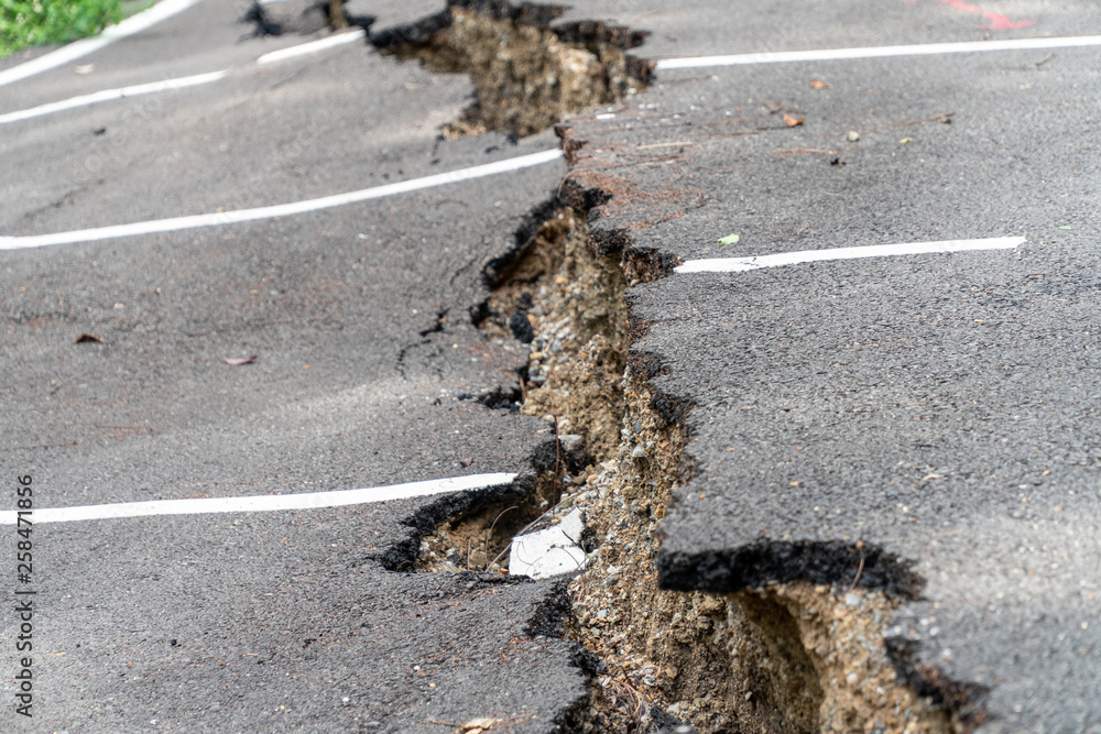 Damaged parking lot collapses with huge cracks by natural disaster ...