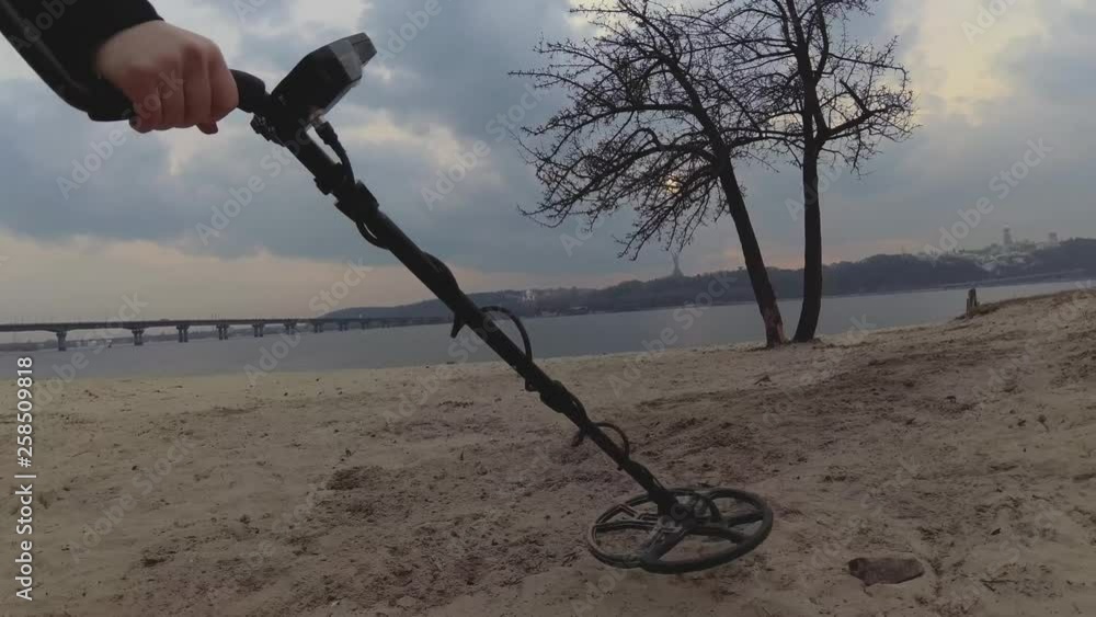 metal detector on the banks of the river is looking for treasure jewels ...