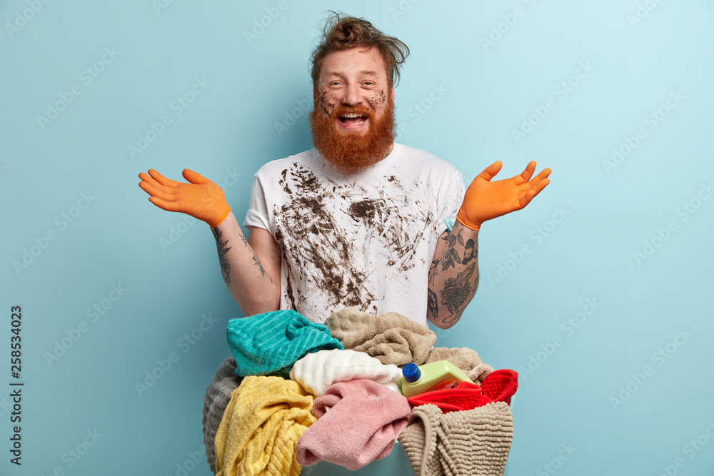 Glad red haired man spreads hands, has clueless expression, being dirty ...
