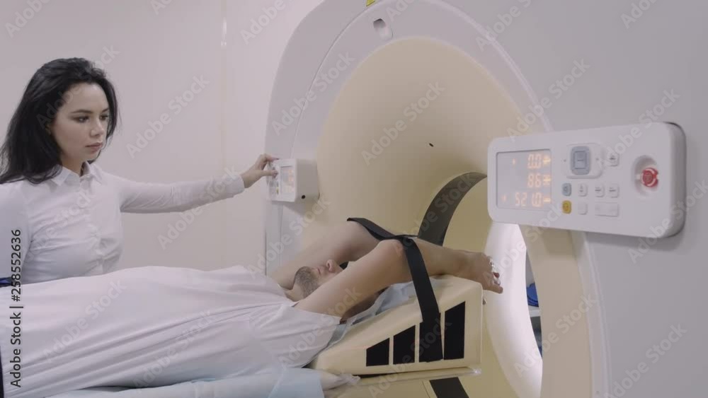 Beautiful nurse switch on ct-scan for diagnostics scanning procedure ...