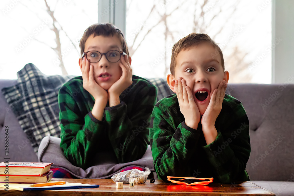 surprised kids on the couch watching tv. the children opened their ...