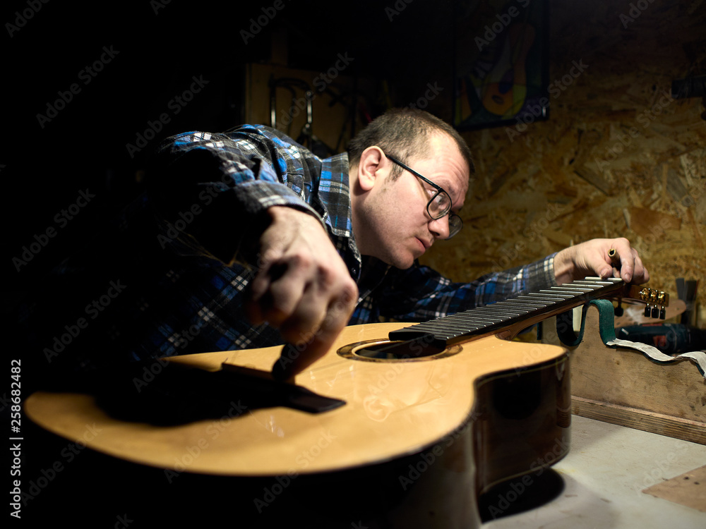 In the guitar workshop, Guitars Luthiers checks the accuracy of the ...