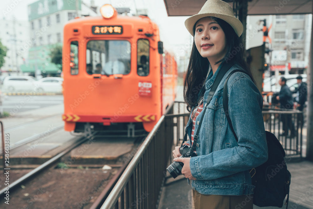 asian smiling female passenger photographer stand on subway platform ...