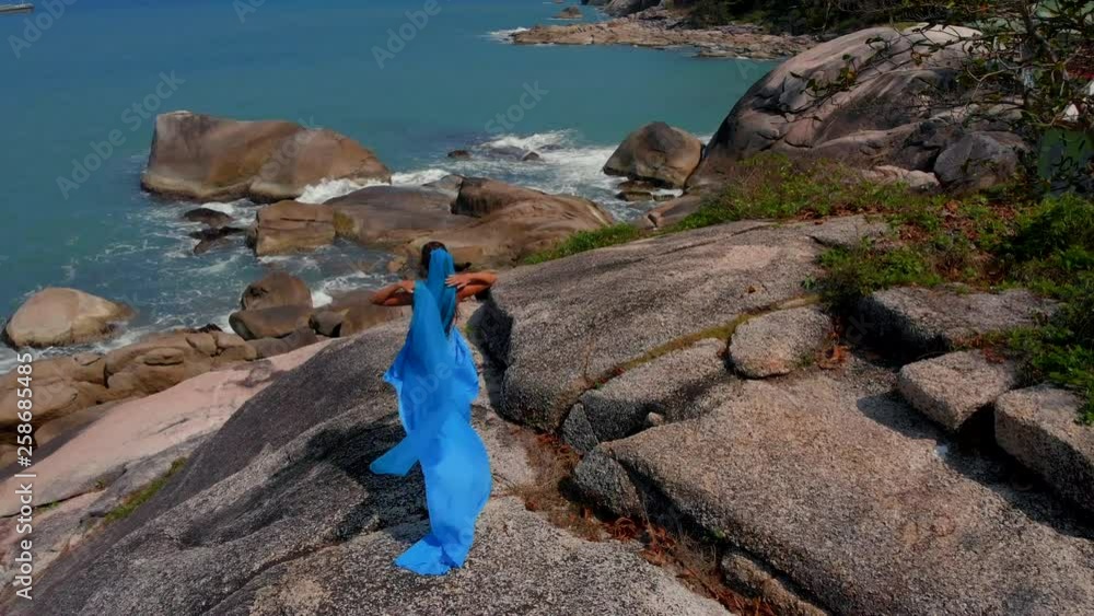 Vidéo Stock Aerial drone view of beautiful brunette girl in blue long ...