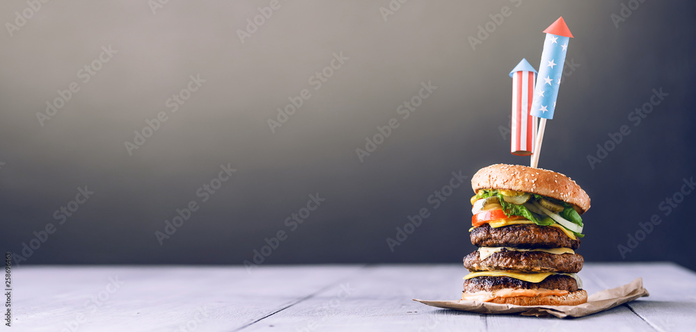 a big burger with three juicy beef patties bonded with American flag ...