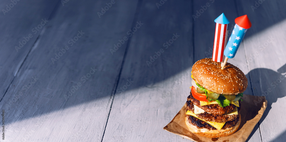 a big burger with three juicy beef patties bonded with American flag ...