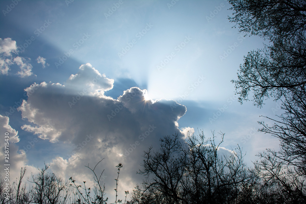Sunbeams shining through grey clouds with silver lining with ...