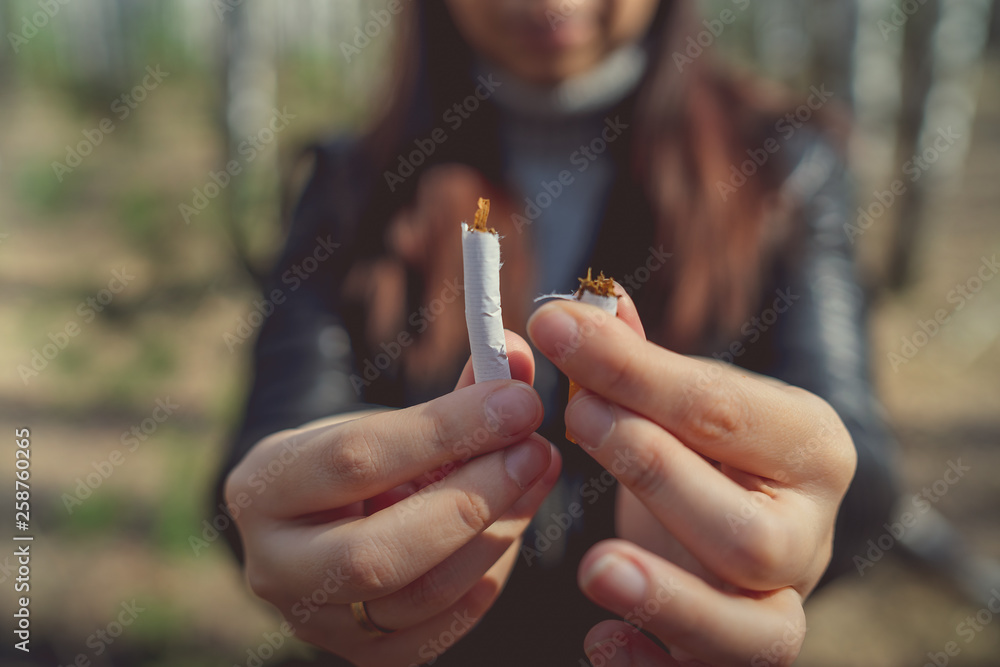 Crop woman breaking cigarette and quitting smoking. Closeup of crop ...