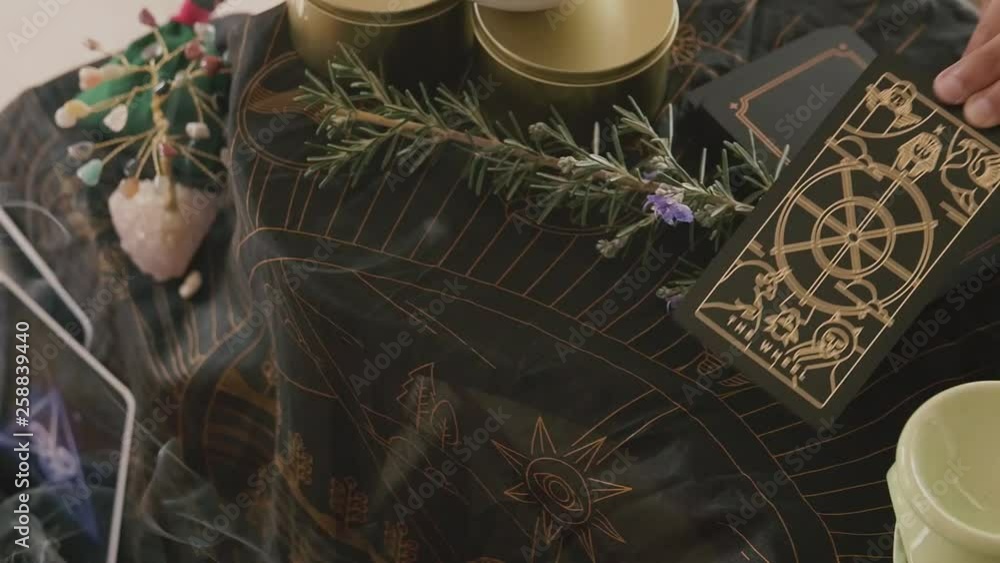 Pan across altar table placing card with incense, tarot cards and oil ...