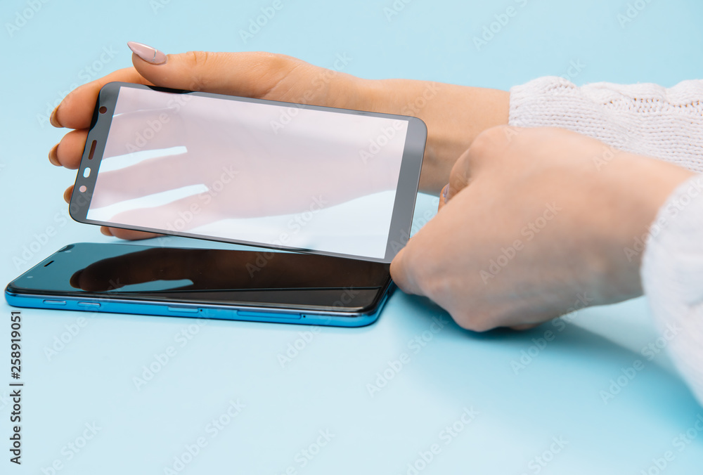 Smartphone with screen protect glass cover in hands. blue background ...