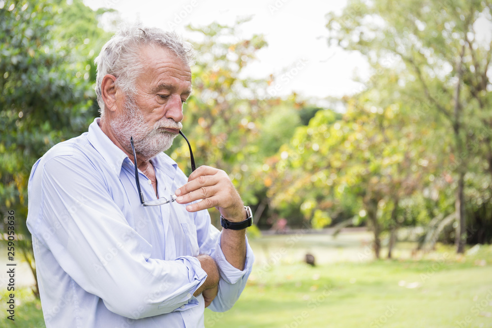 Portrait of stressful sad senior caucasian old man in the park outdoors ...