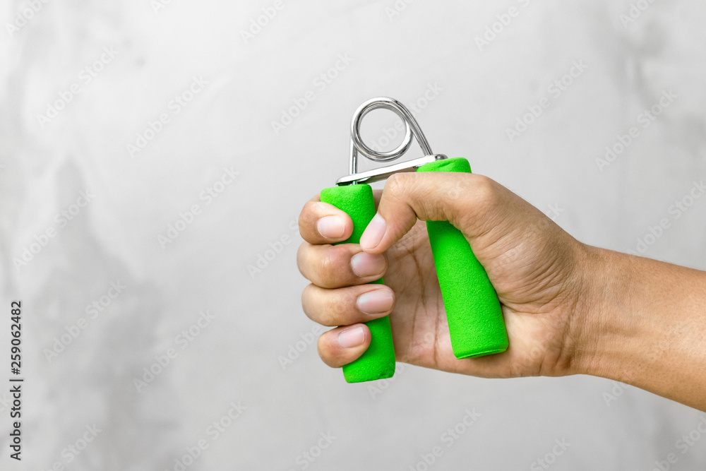 Strong hand holding grip in gym background. Grip strength for exercise ...