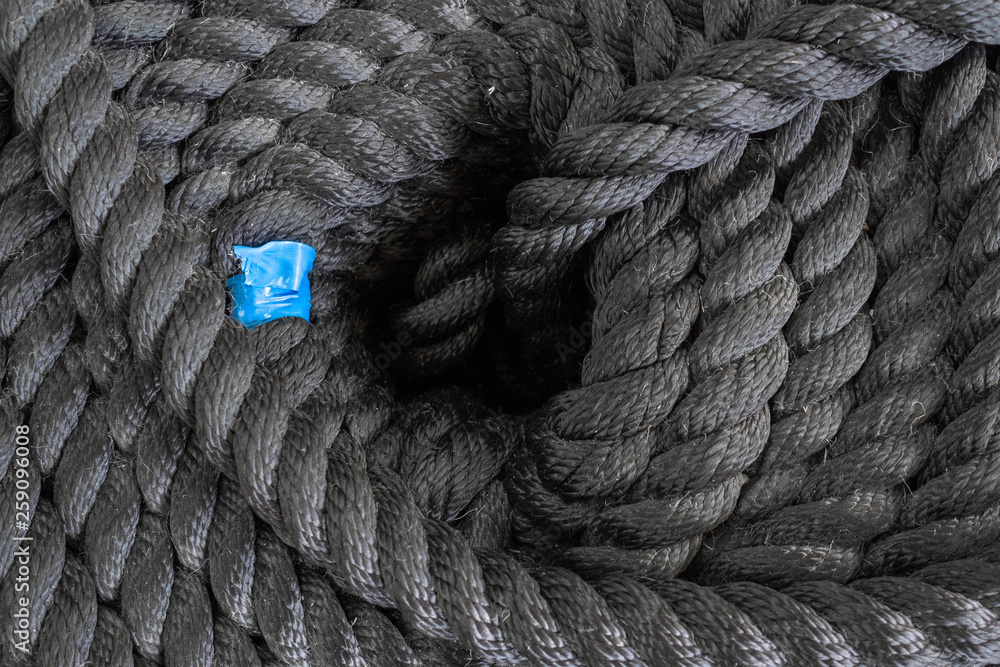 Foto de The thick black rope twisted in a roll. The top view on a rope ...