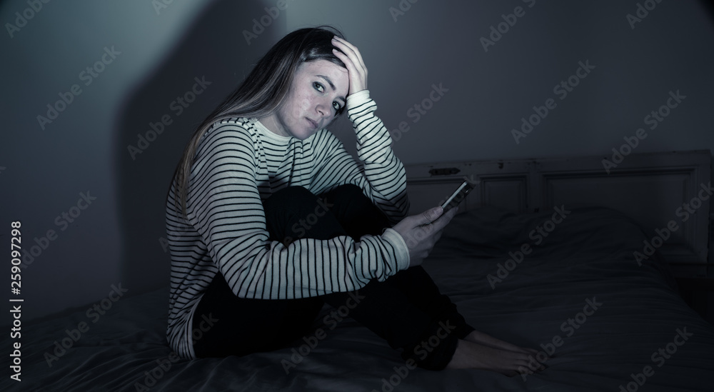 Depressed teenager girl on mobile phone victim of cyberbullying feeling ...