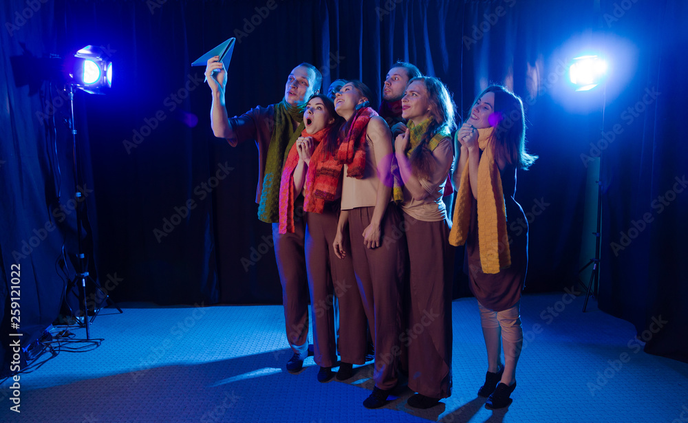 The actors on the stage play a performance and look at a blue paper ...