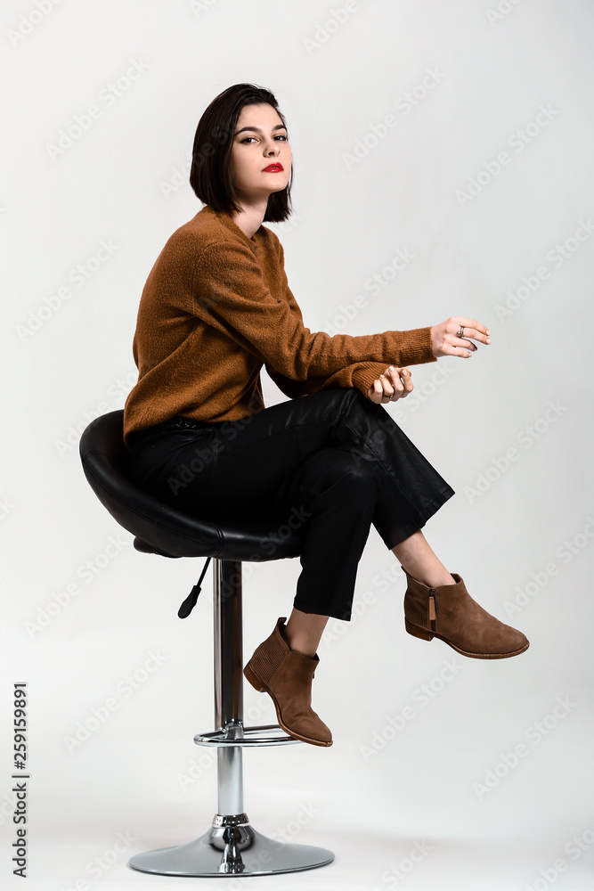 Beautiful young woman in modern stylish clothes on light background ...