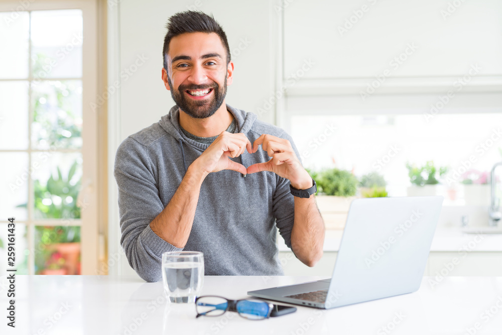Handsome hispanic man working using computer laptop smiling in love ...
