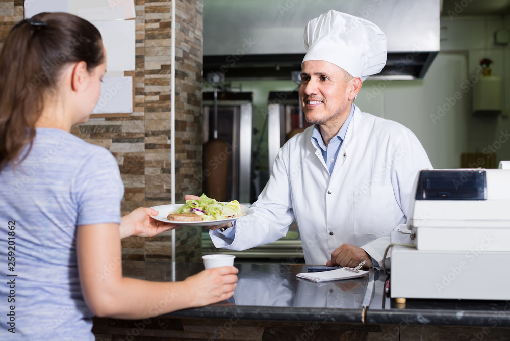 man cook serving fresh kebab dish to customer on counter in fast food ...