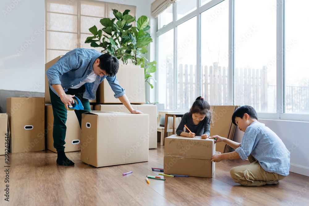 Father packing while kids playing at home Stock Photo | Adobe Stock