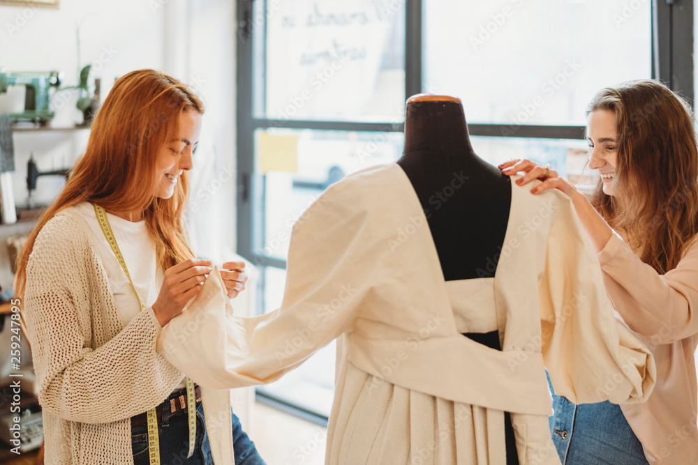 Female fashion designers dressing the mannequin Stock Photo | Adobe Stock