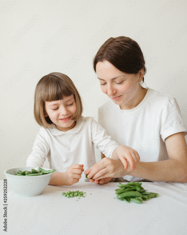 Mother and daughter sorting peas Stock Photo | Adobe Stock