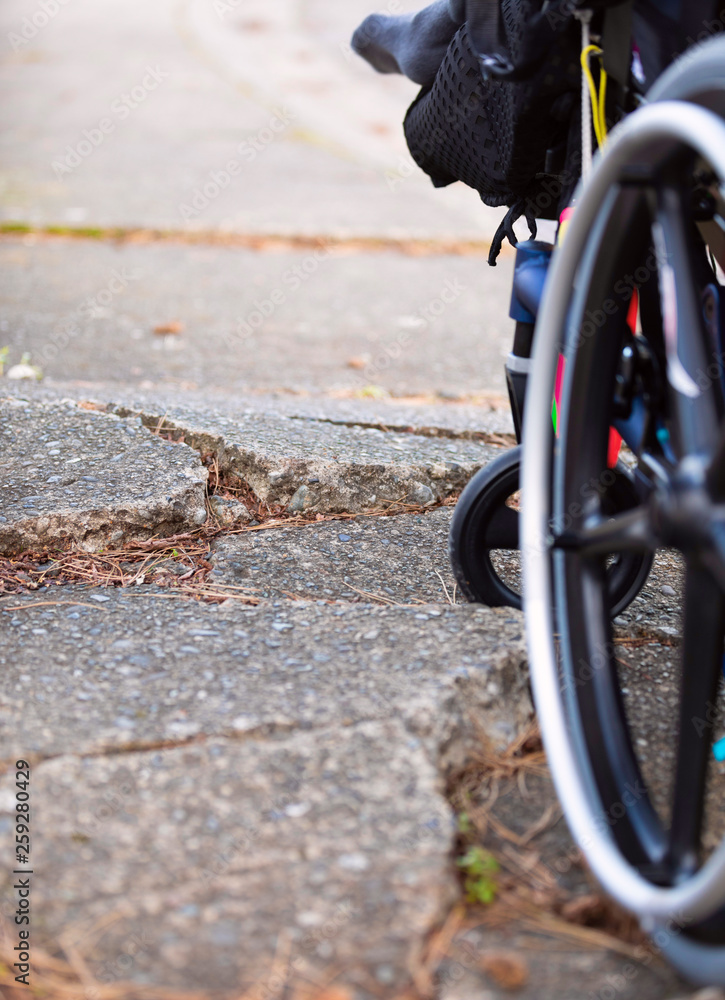 Wheelchair wheels up against cracks in broken sidewalk Stock Photo ...