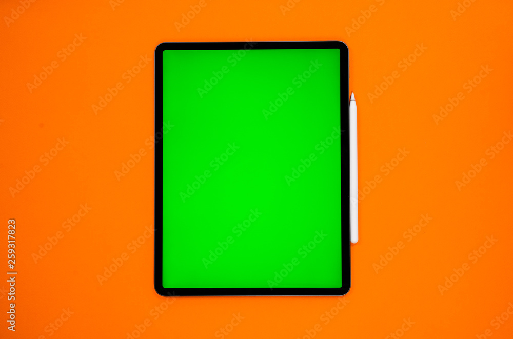 new tablet on a Orange background with a keyboard and pen, and green ...