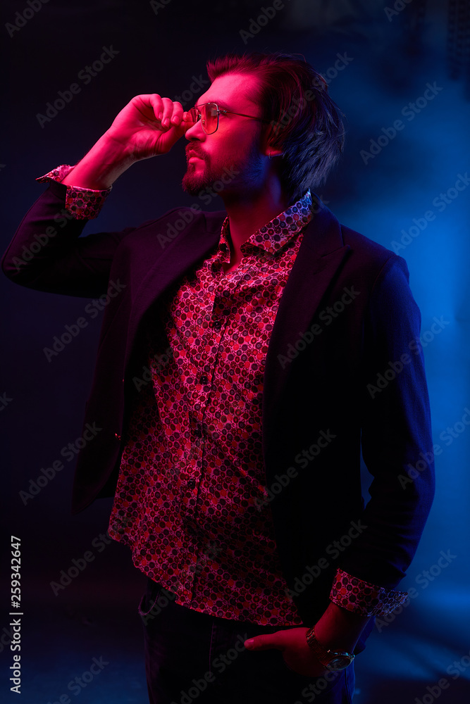 Neon light portrait of handsome male model with dark medium length hair ...