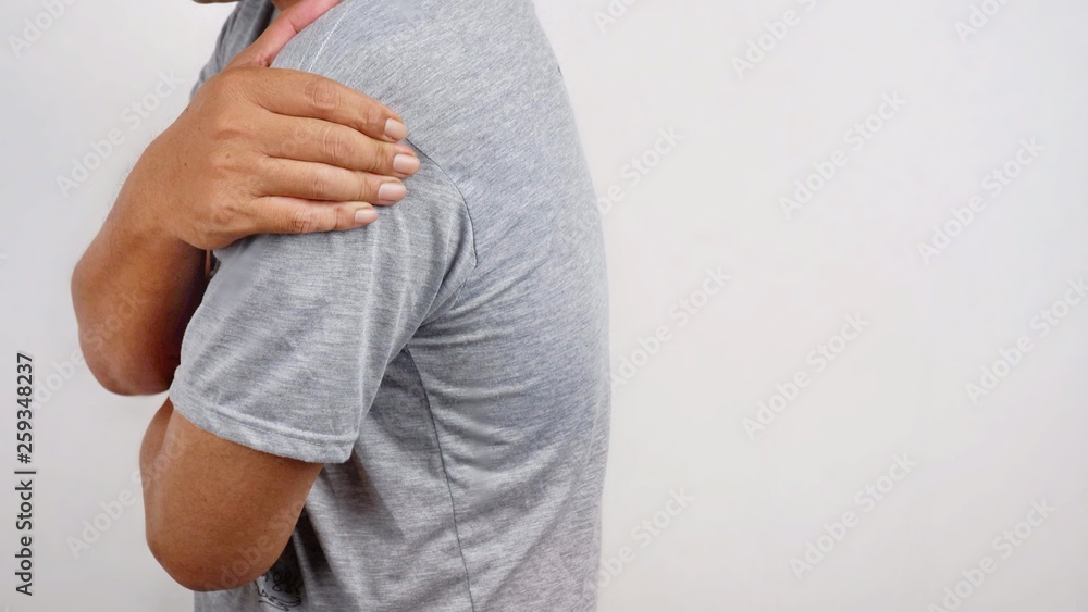 Side view of man in gray t shirt with shoulder or upper arm pain with ...