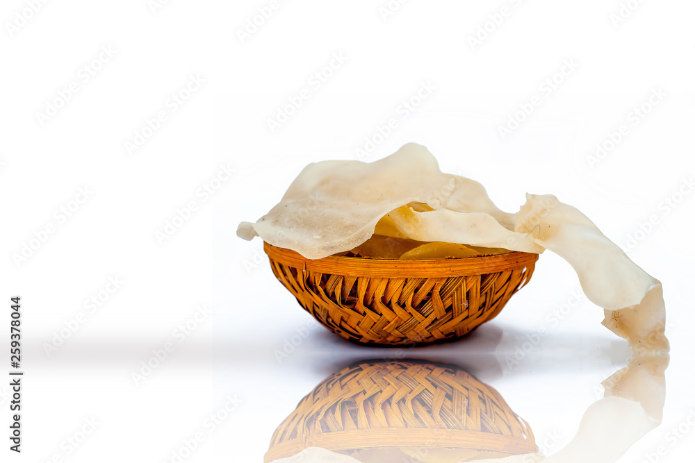 Papad or papadum in a clay bowl isolated on white with its reflection ...