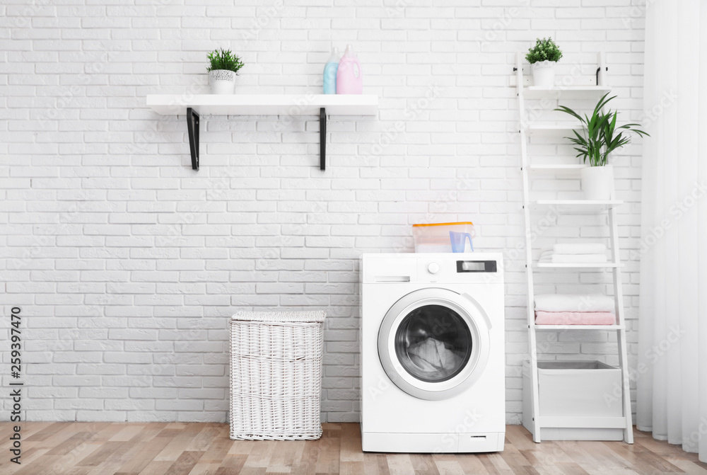 Modern washing machine near brick wall in laundry room interior, space ...