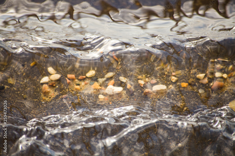 Background water. Asphalt and sand. Stream of water over the asphalt ...