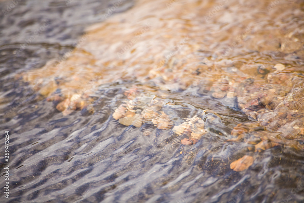 Background water. Asphalt and sand. Stream of water over the asphalt ...