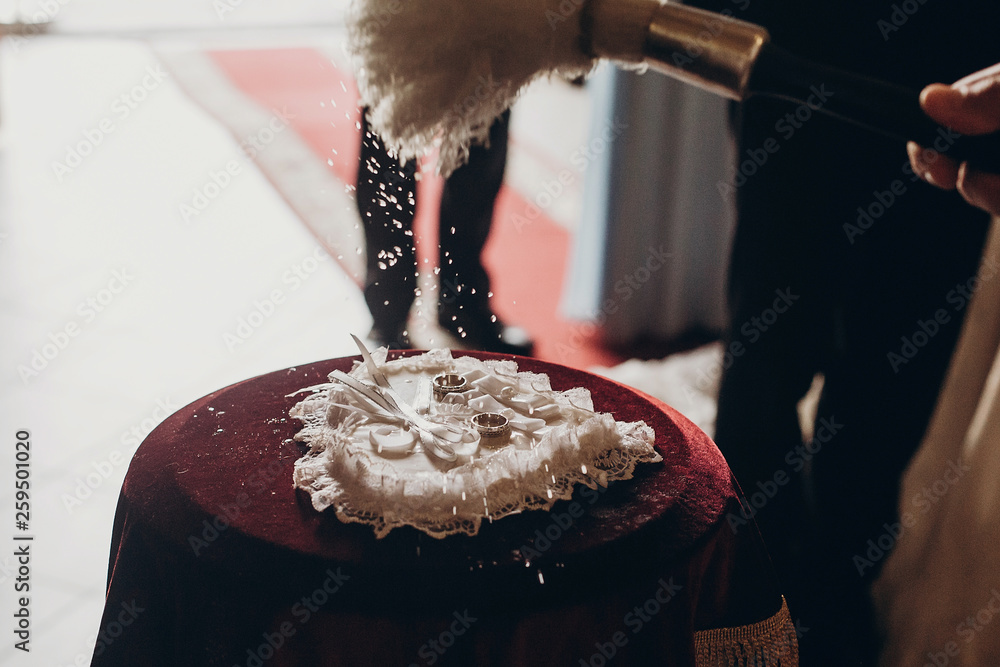 luxury golden wedding rings on heart shaped silk pillow, priest ...