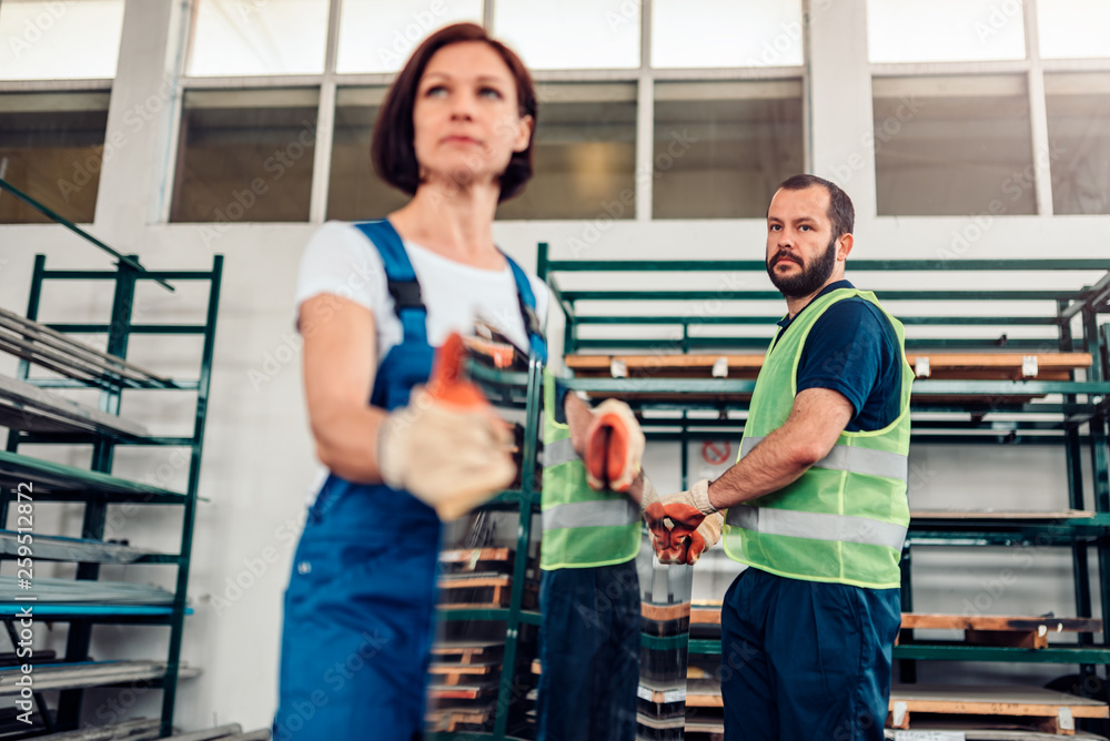 Warehouse workers carrying stainless steel inox sheet metal in factory ...