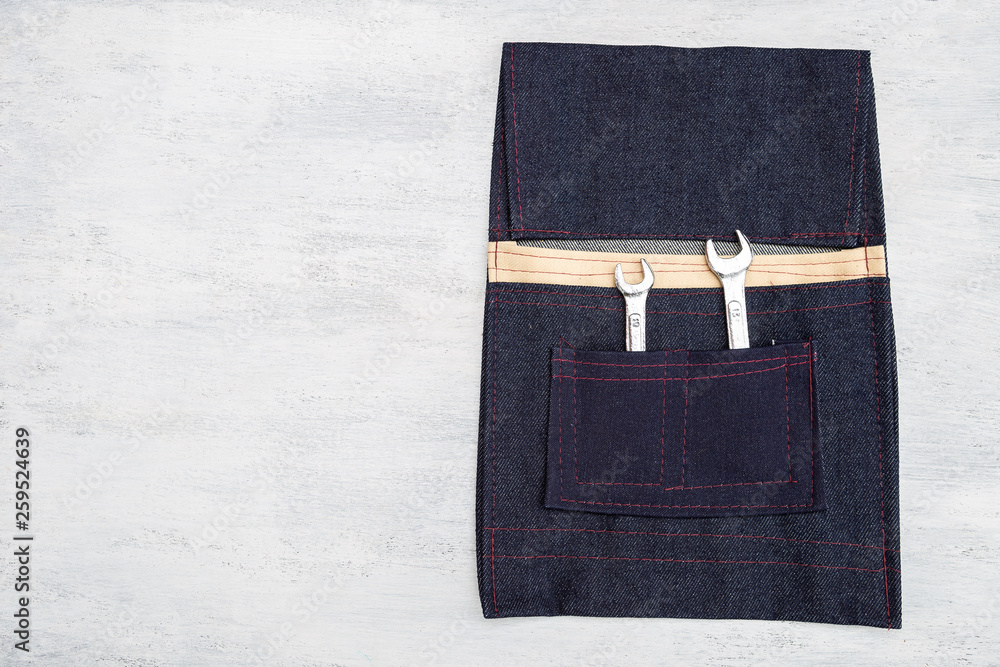 Metal tool in jean fabric tool bag on white texture background ...