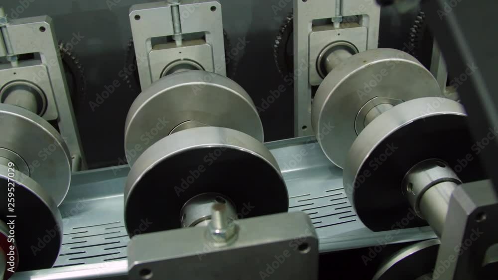Closeup of rollers that feed the automatic production line in a metal ...
