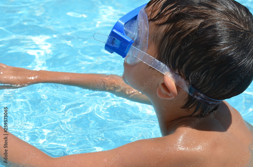Teenager boy wearing mask swimming in the pool. Happy holiday concept ...