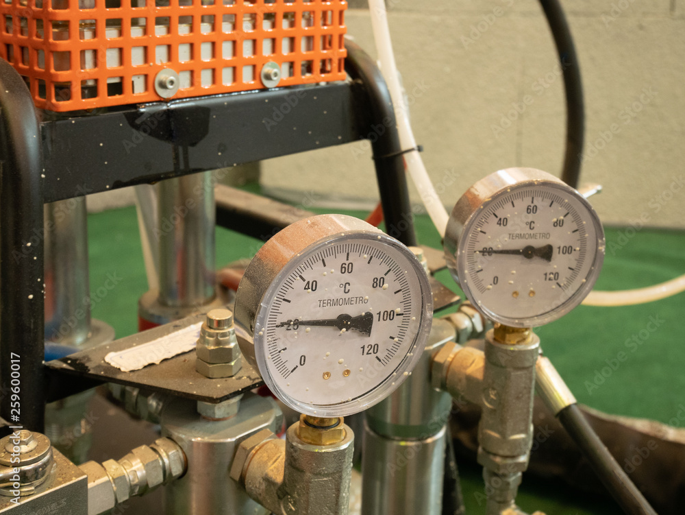 closeup of two analog indicators of temperature with arrows showing ...